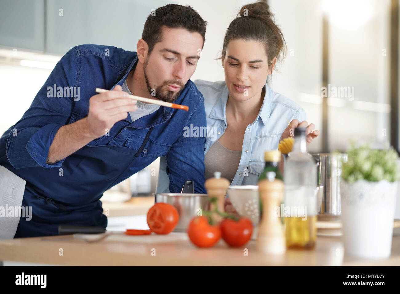 Couple at home having fun cooking together Stock Photo - Alamy