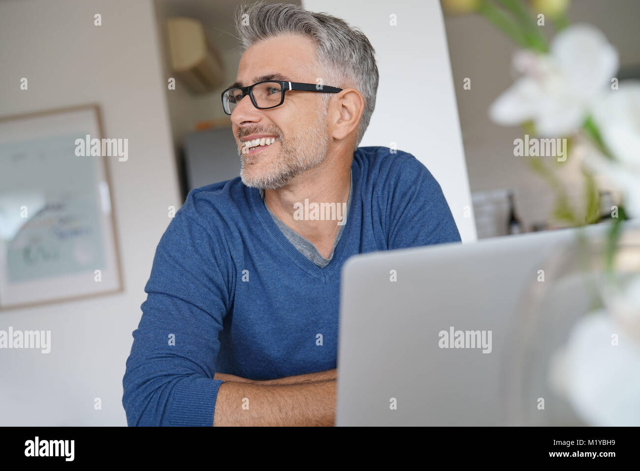 Middle-aged man working from home-office on laptop Stock Photo - Alamy