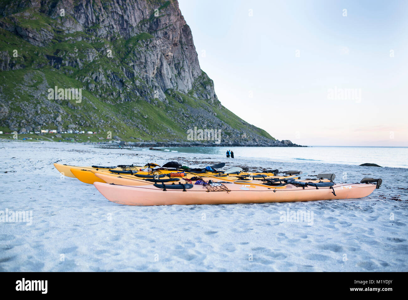 Five kayaks in the sand at the beach a little bit from the ocean at ...
