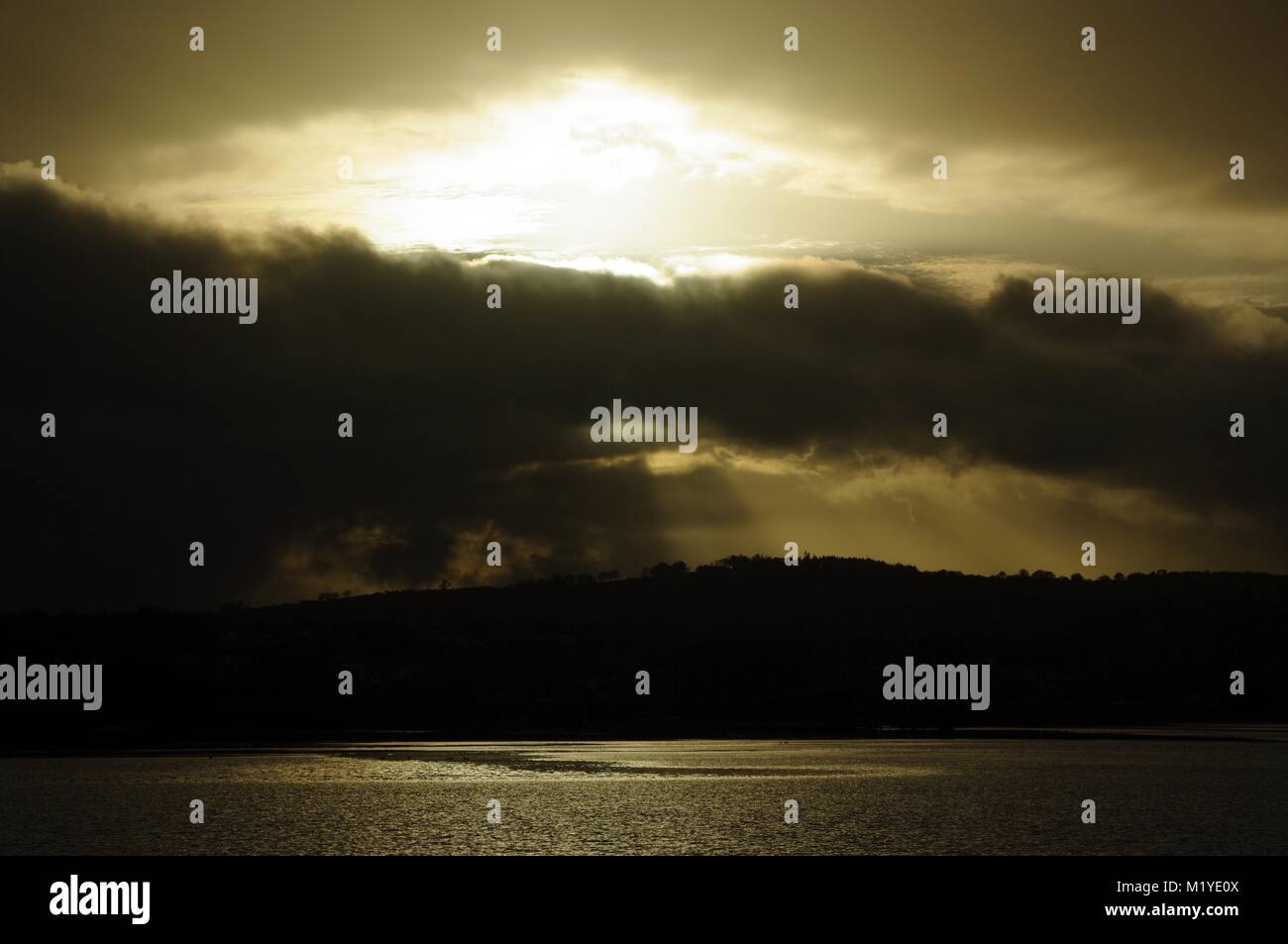 Light Golden Sunset and Sunrays from Brooding Ominous Stratus ...
