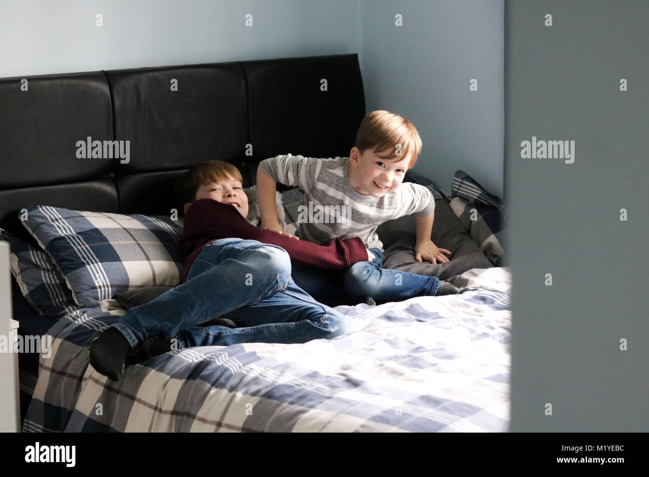Brothers playing on bed in bedroom Stock Photo - Alamy