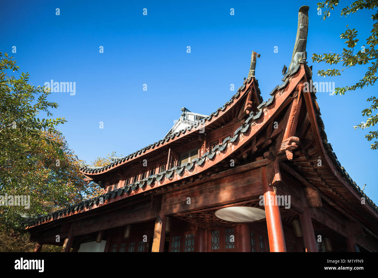 Traditional Chinese wooden gazebo roof under blue sky. Coast of West ...