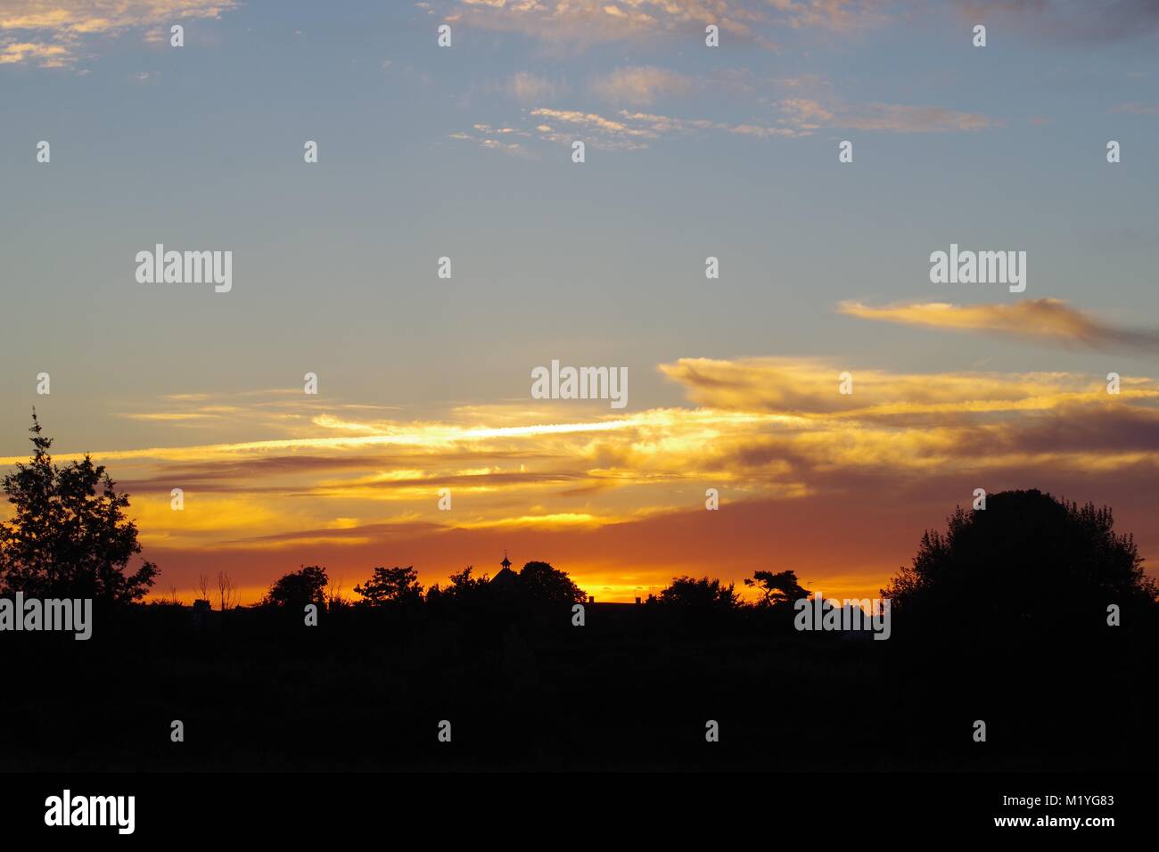 A Beautiful Firery Sunset, Silhouetting the Treeline and a Country ...