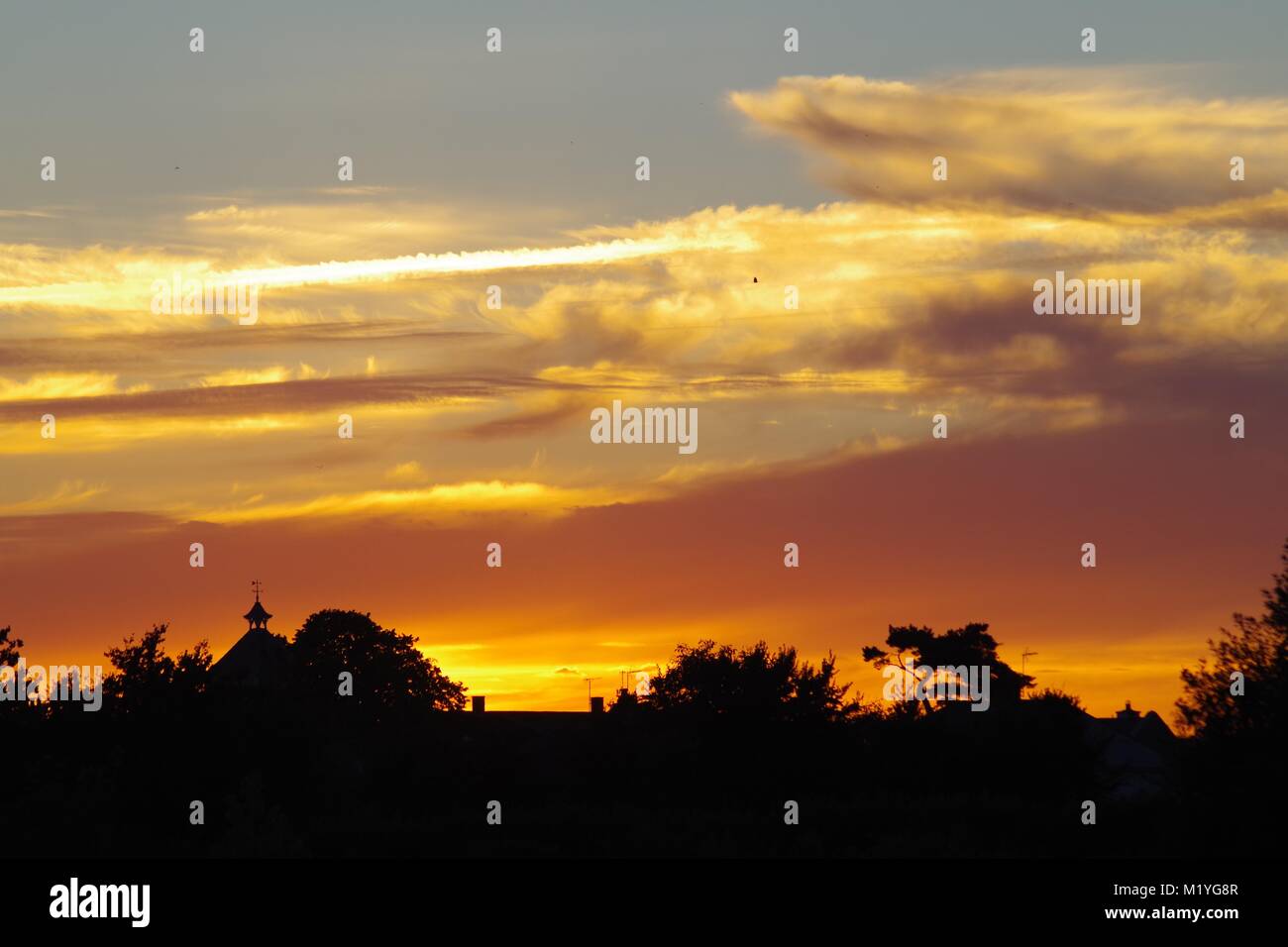 A Beautiful Firery Sunset, Silhouetting the Treeline and a Country ...