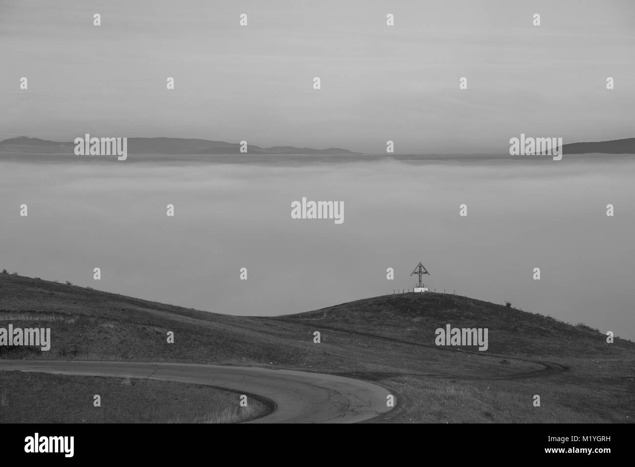 Black and white picture of small wooden cross on a hill overlooking a ...