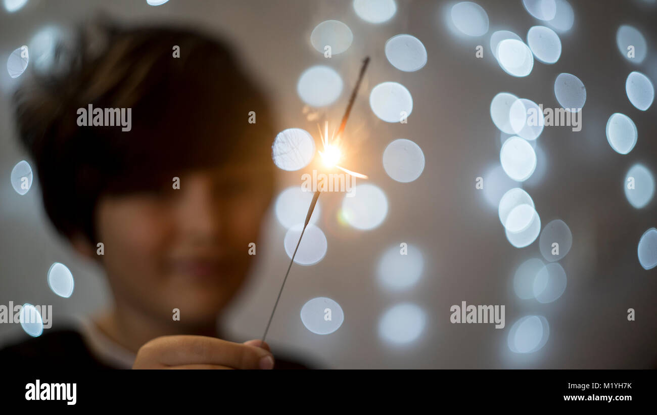 fireworks, child with flares of lights and Christmas lights in the ...