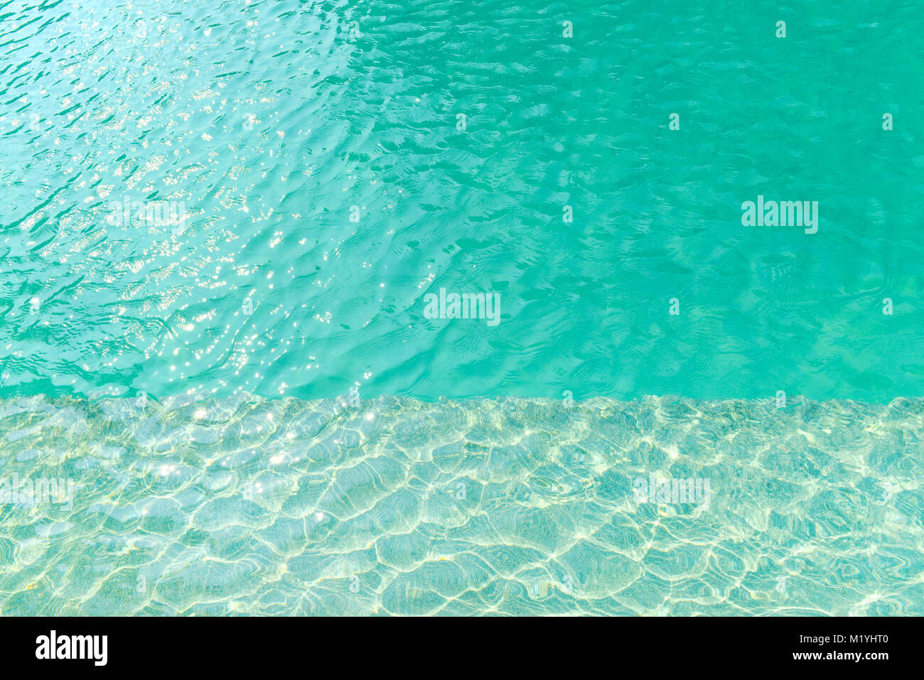 Swimming pool blue water with a wave and sunlight reflection effect ...