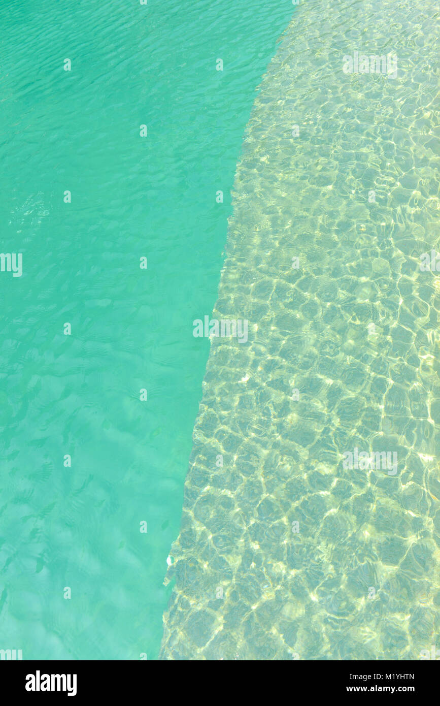 Swimming pool blue water with a wave and sunlight reflection effect ...