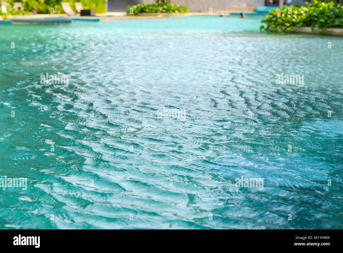 Swimming pool blue water with a wave and sunlight reflection effect at ...