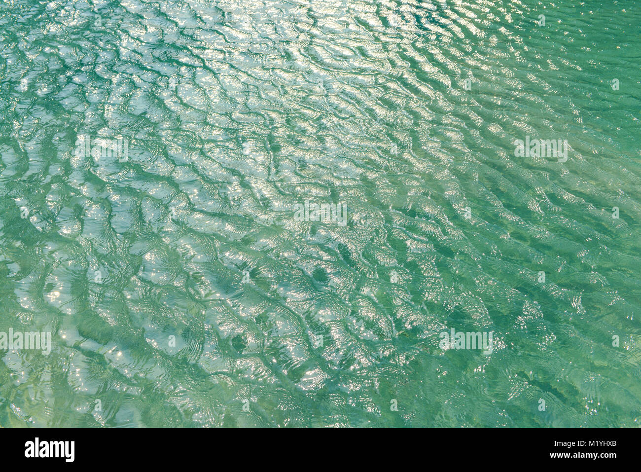 Swimming pool blue water with a wave and sunlight reflection effect ...