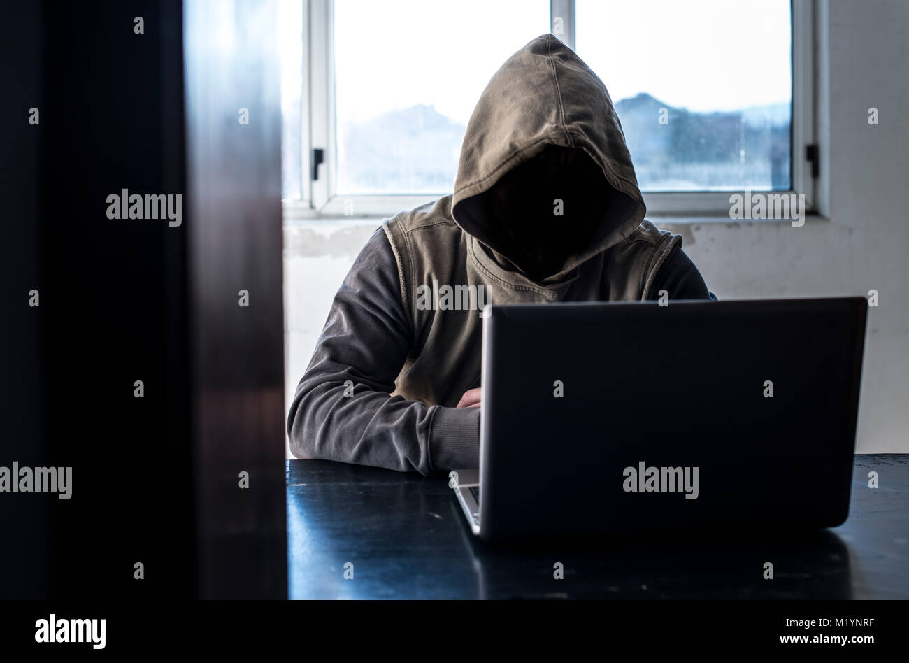 Hacker with hood Stock Photo - Alamy