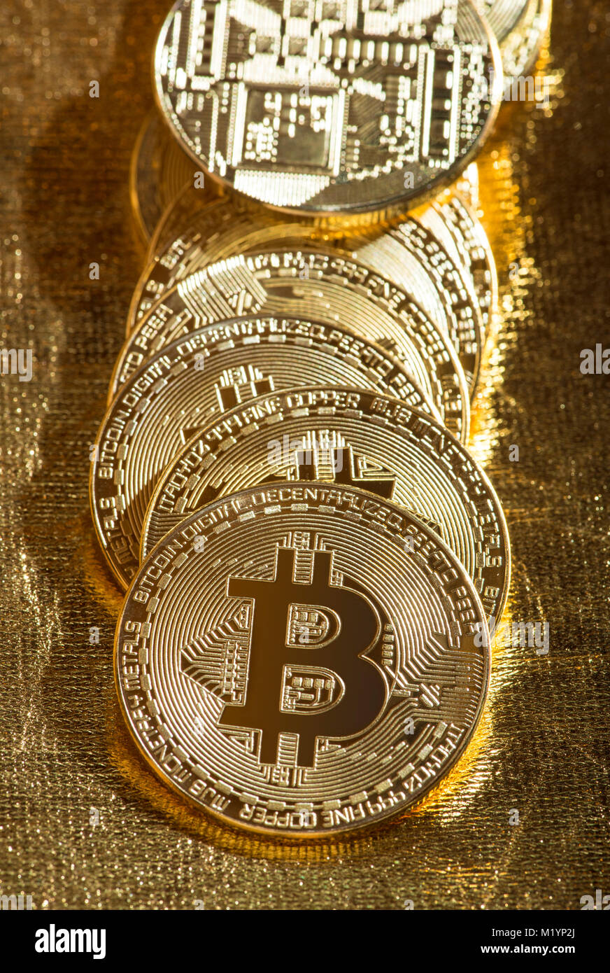 Many Bitcoin coins on gold background Stock Photo - Alamy