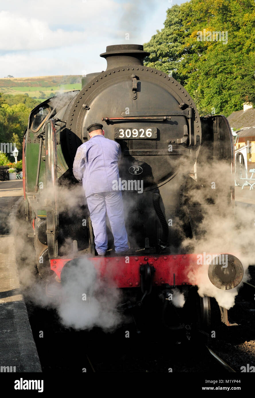 The driver/fireman of SR loco No 30926 'Repton' attends to the headlamp ...
