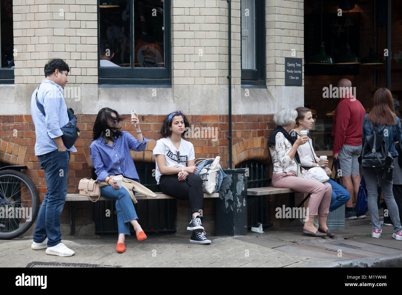 LONDON, ENGLAND - AUGUST 22, 2017 Young people drinking coffee sitting ...