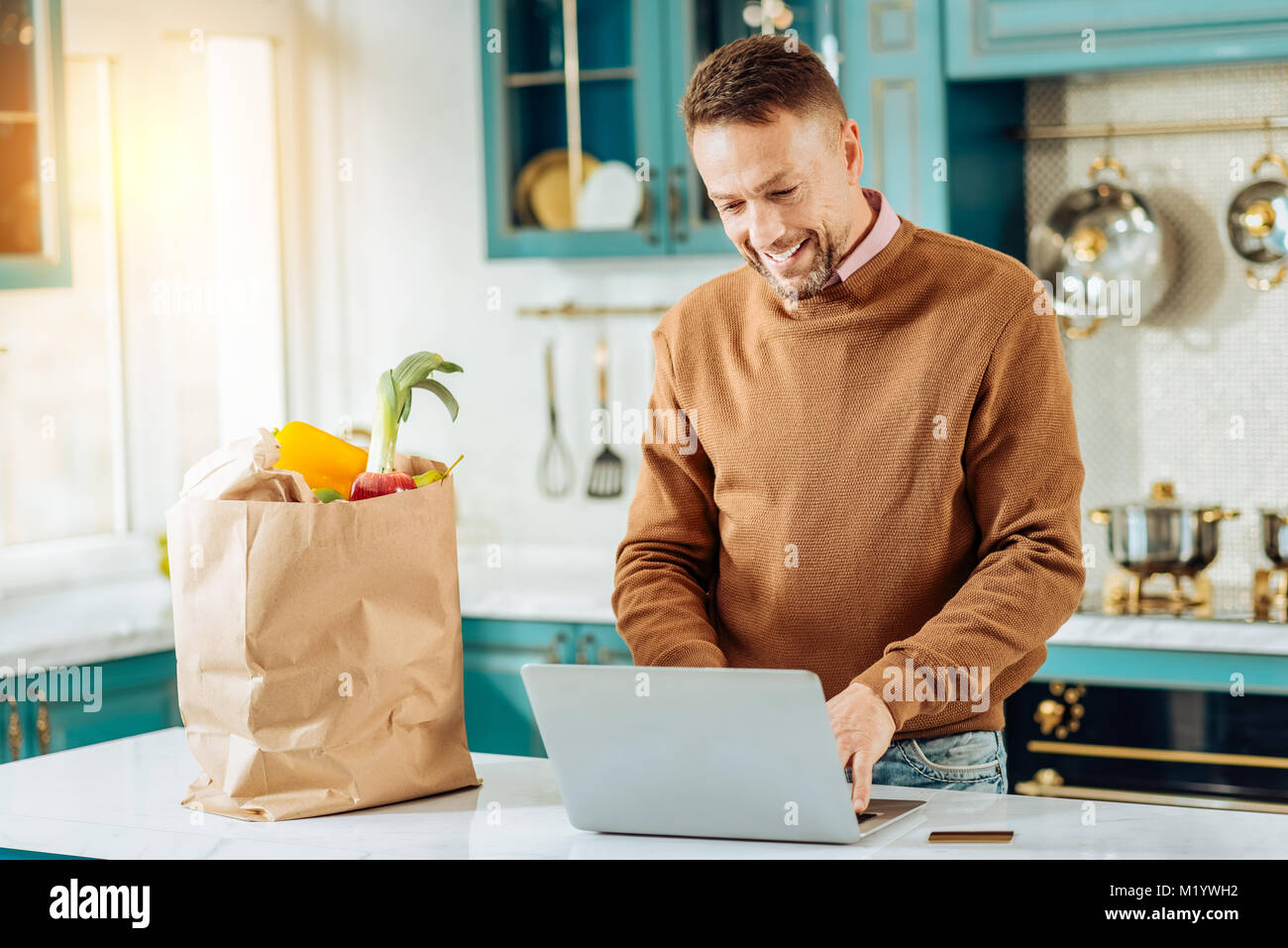 Positive cheerful man typing on the laptop Stock Photo - Alamy
