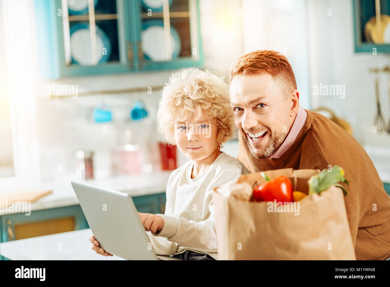 Positive small boy pointing at the laptop screen Stock Photo - Alamy