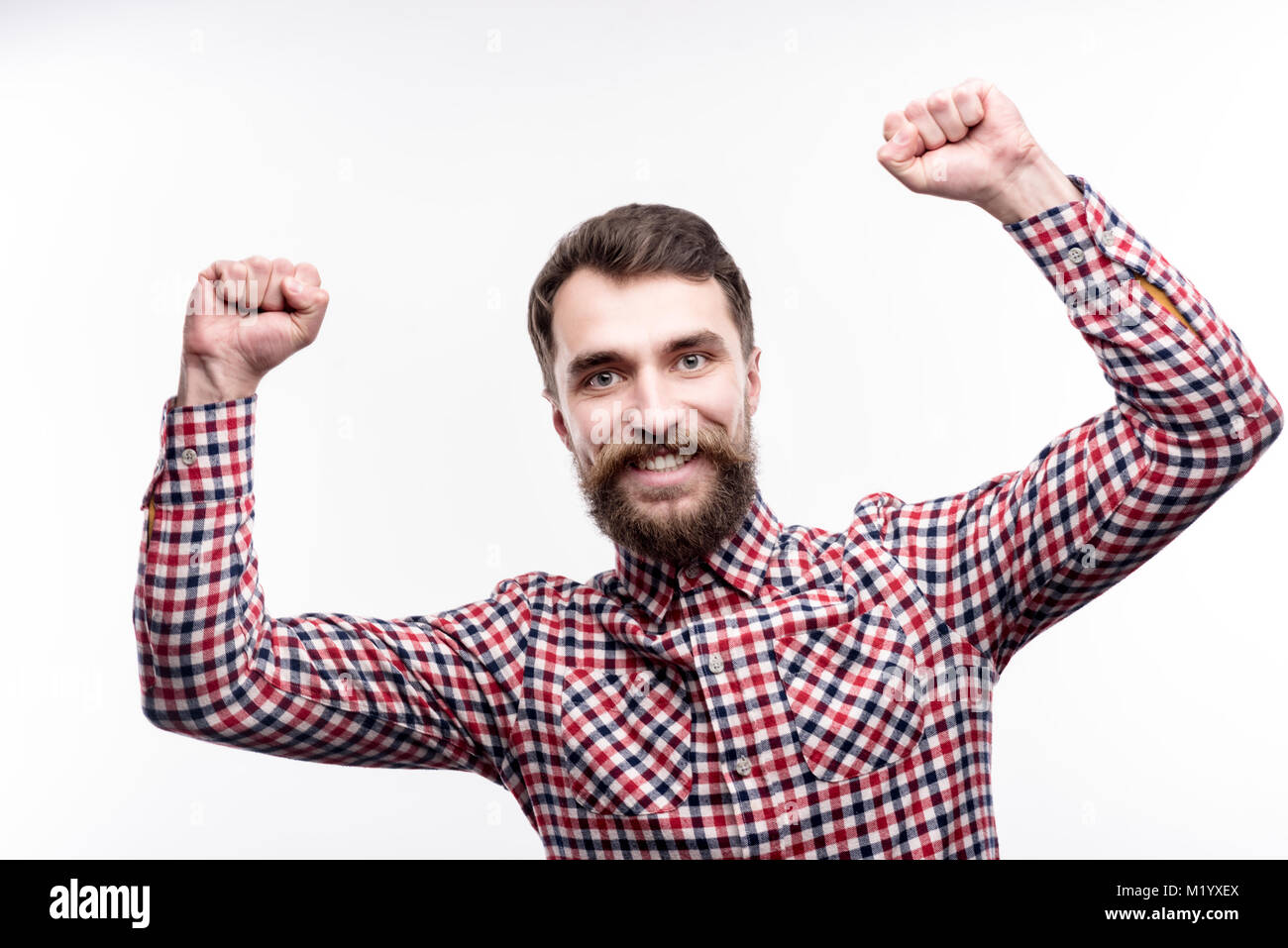Upbeat bearded man raising his hands after success Stock Photo - Alamy