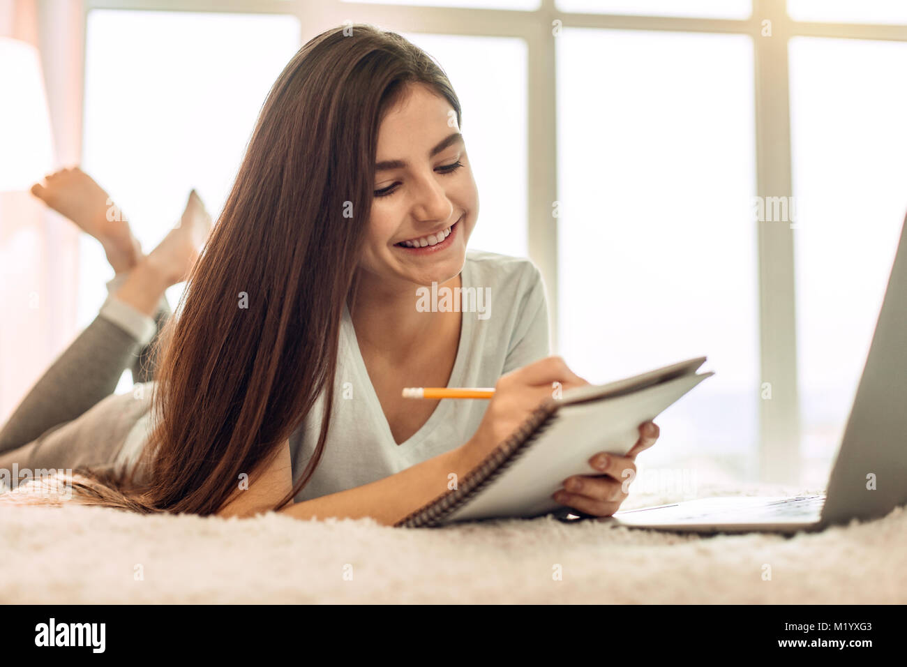 Pretty female student doing her home assignment Stock Photo - Alamy