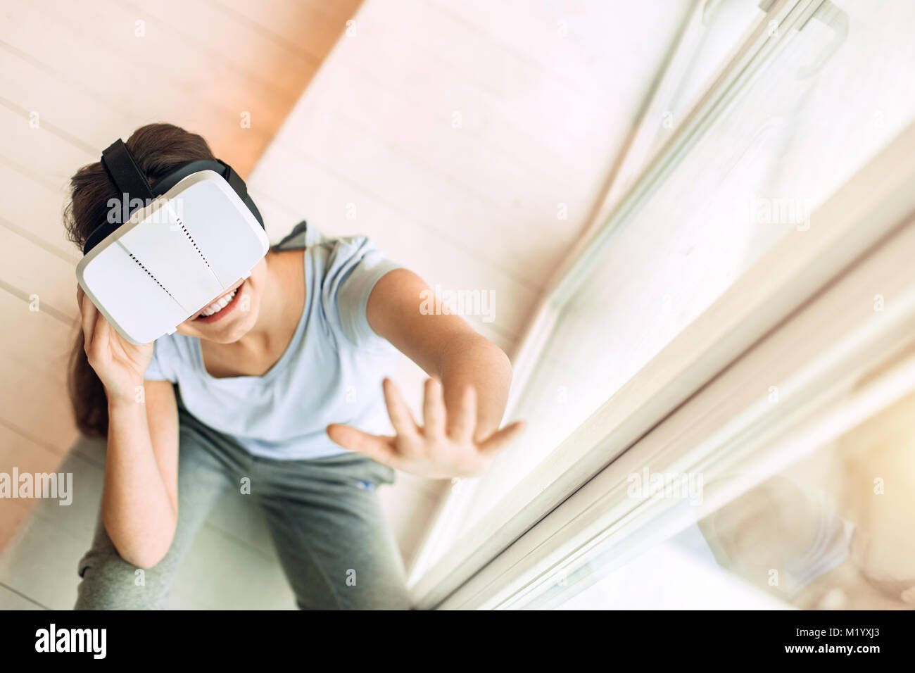 Top view of teenage girl in VR headset raising hand Stock Photo - Alamy