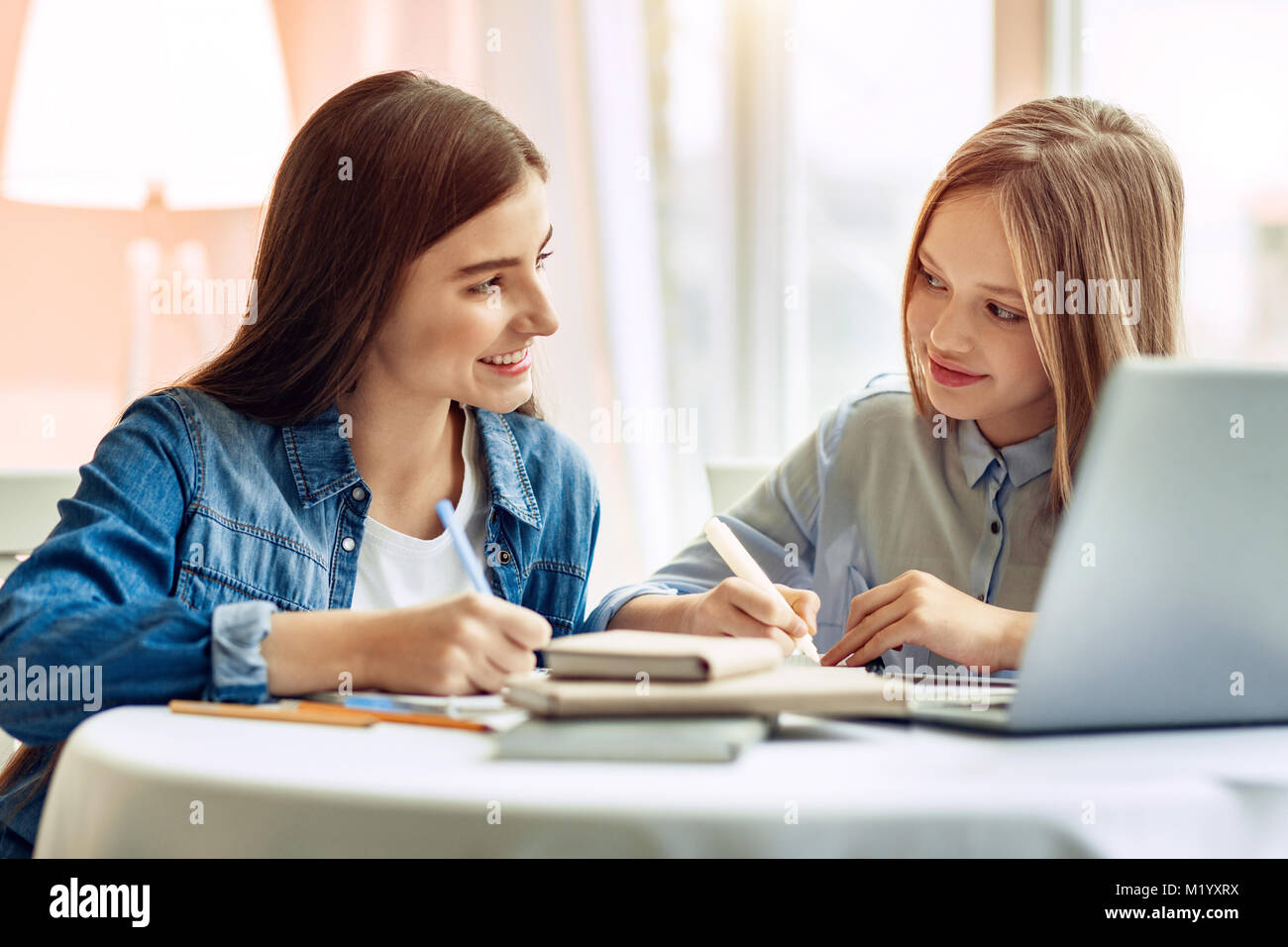 Cheerful best friends doing home assignment together Stock Photo - Alamy