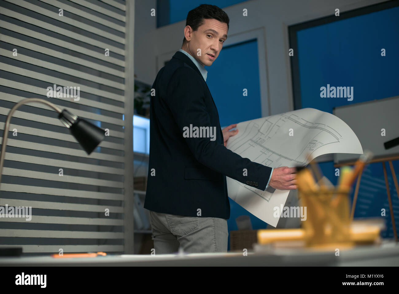 Handsome male engineer working with blueprint Stock Photo - Alamy