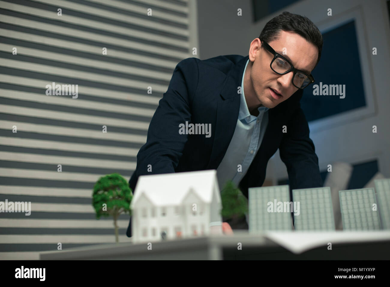 Musing male engineer working on model Stock Photo - Alamy