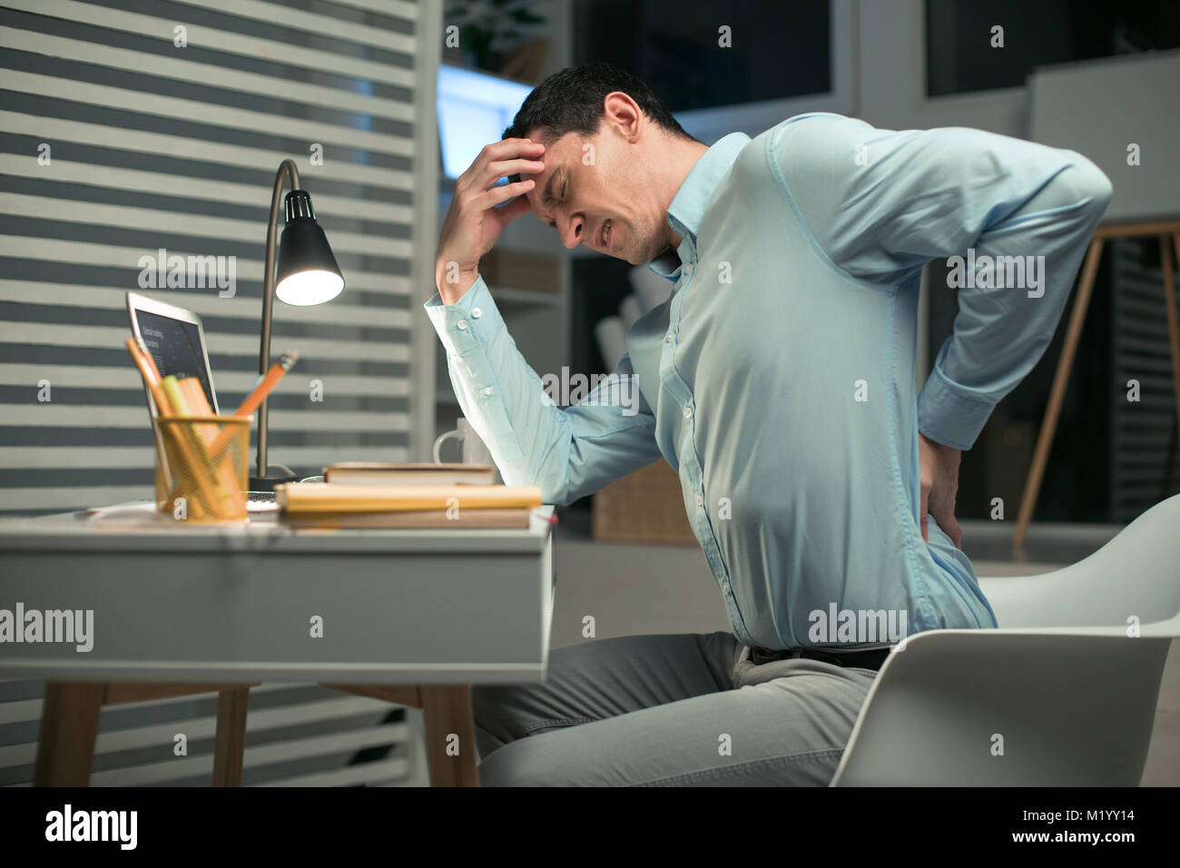 Sad male employee exhausted by work Stock Photo - Alamy