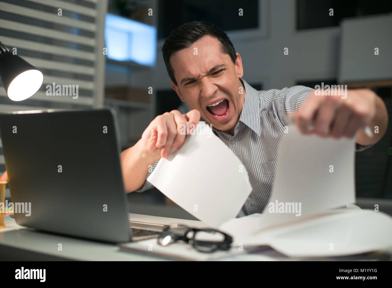 Attractive male employee rending papers Stock Photo - Alamy