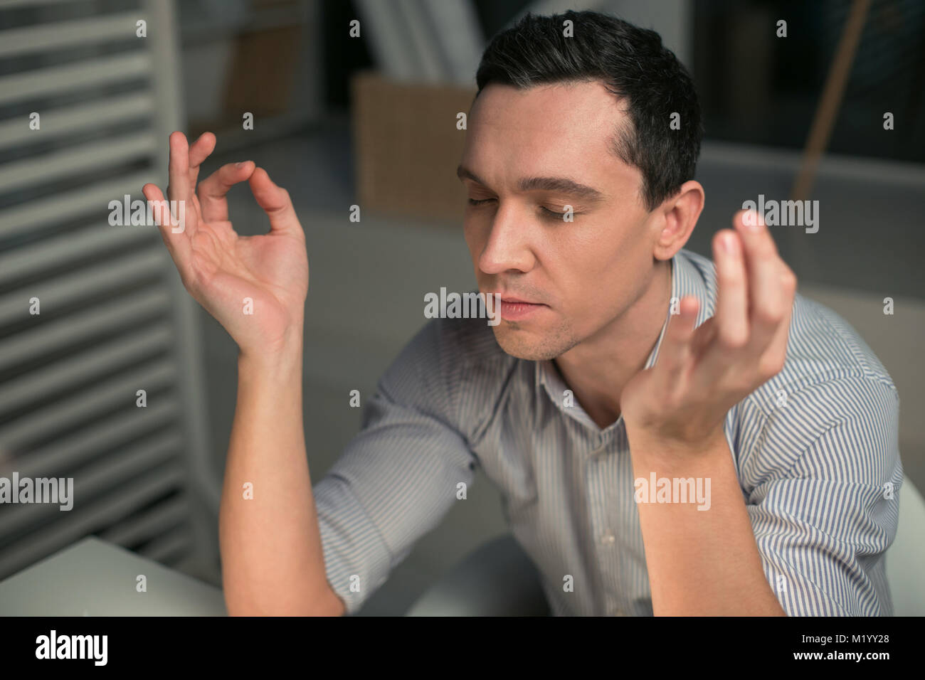 Calm male employee calming down Stock Photo - Alamy