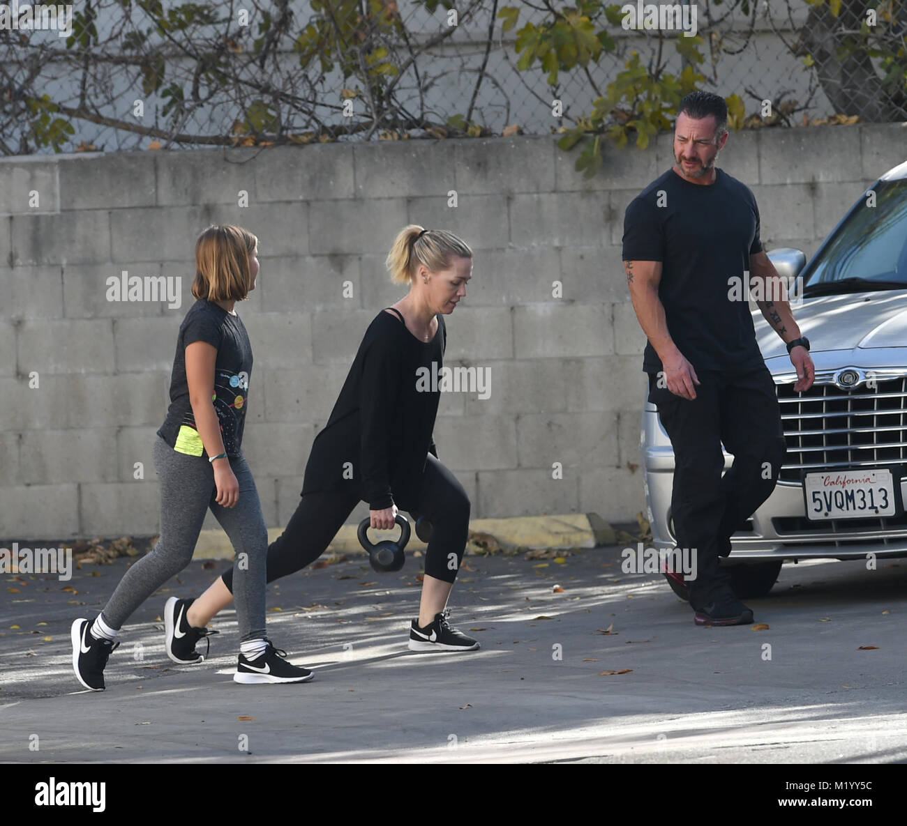 Jennie Garth does lunges with kettle bells with encouragement from her ...
