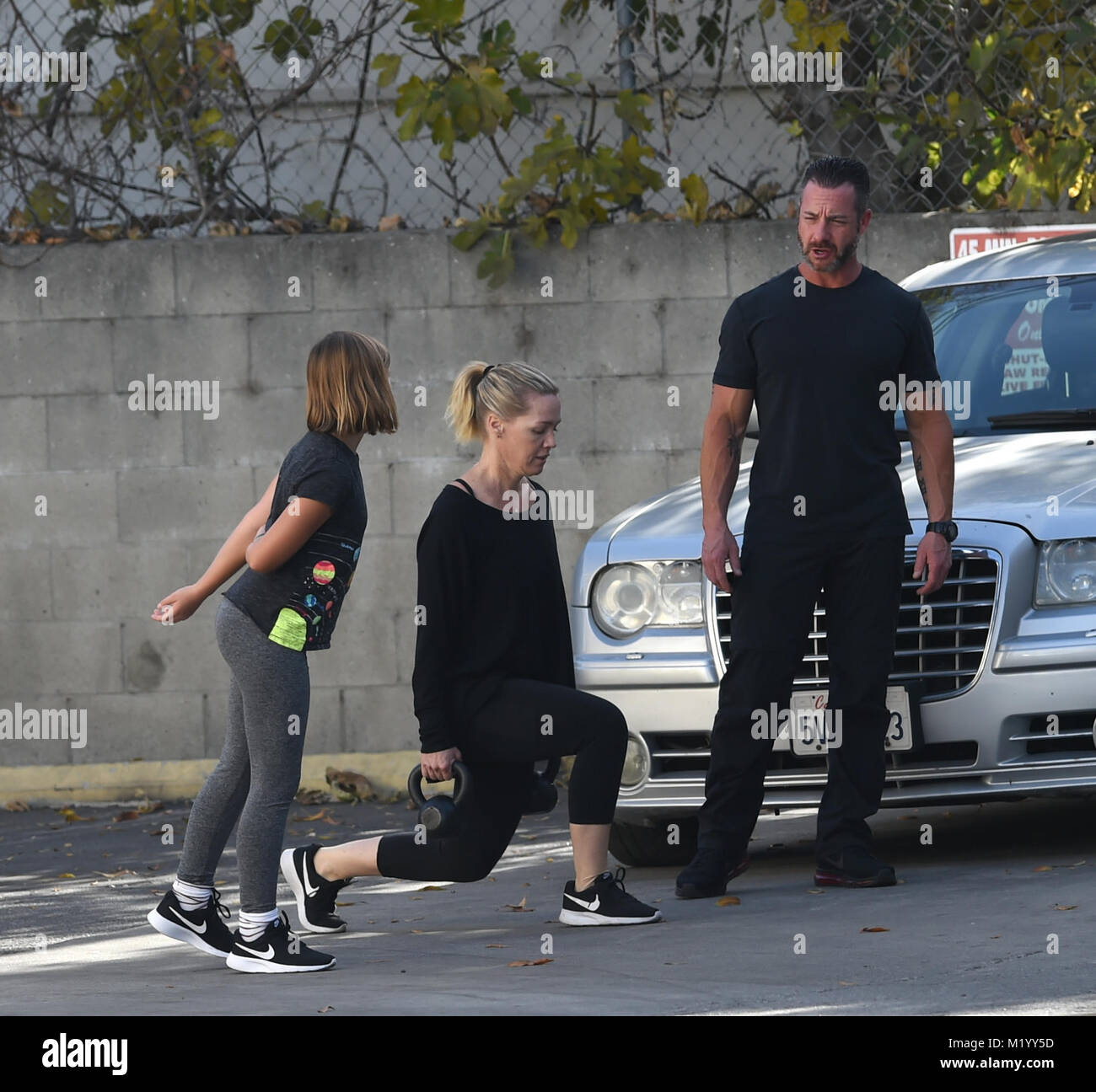 Jennie Garth does lunges with kettle bells with encouragement from her ...