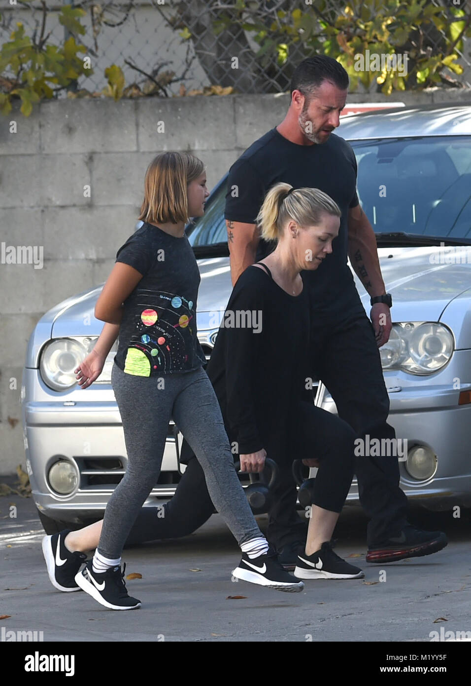 Jennie Garth does lunges with kettle bells with encouragement from her ...