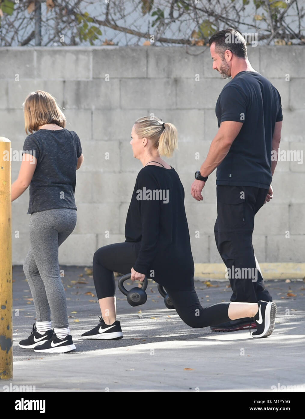 Jennie Garth does lunges with kettle bells with encouragement from her ...