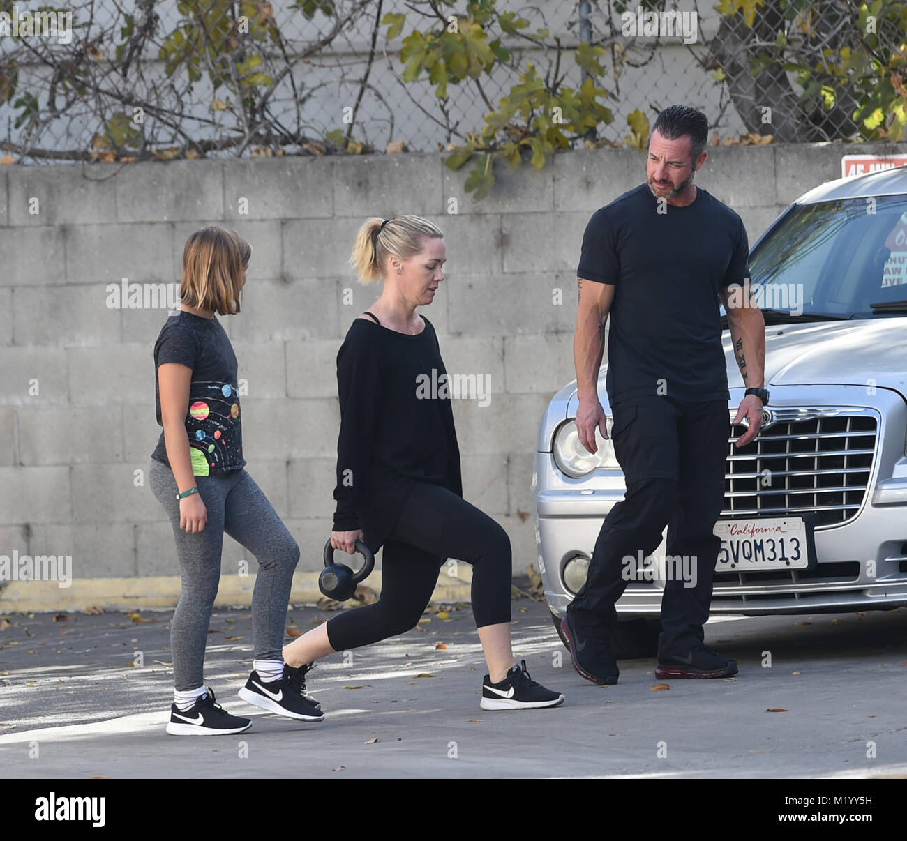 Jennie Garth does lunges with kettle bells with encouragement from her ...