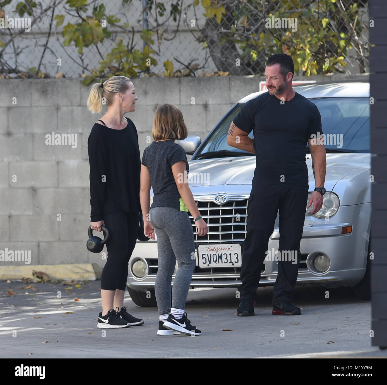 Jennie Garth does lunges with kettle bells with encouragement from her ...