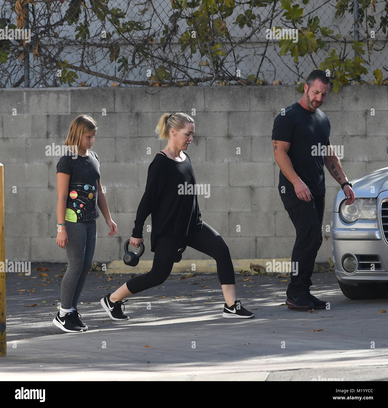 Jennie Garth does lunges with kettle bells with encouragement from her ...