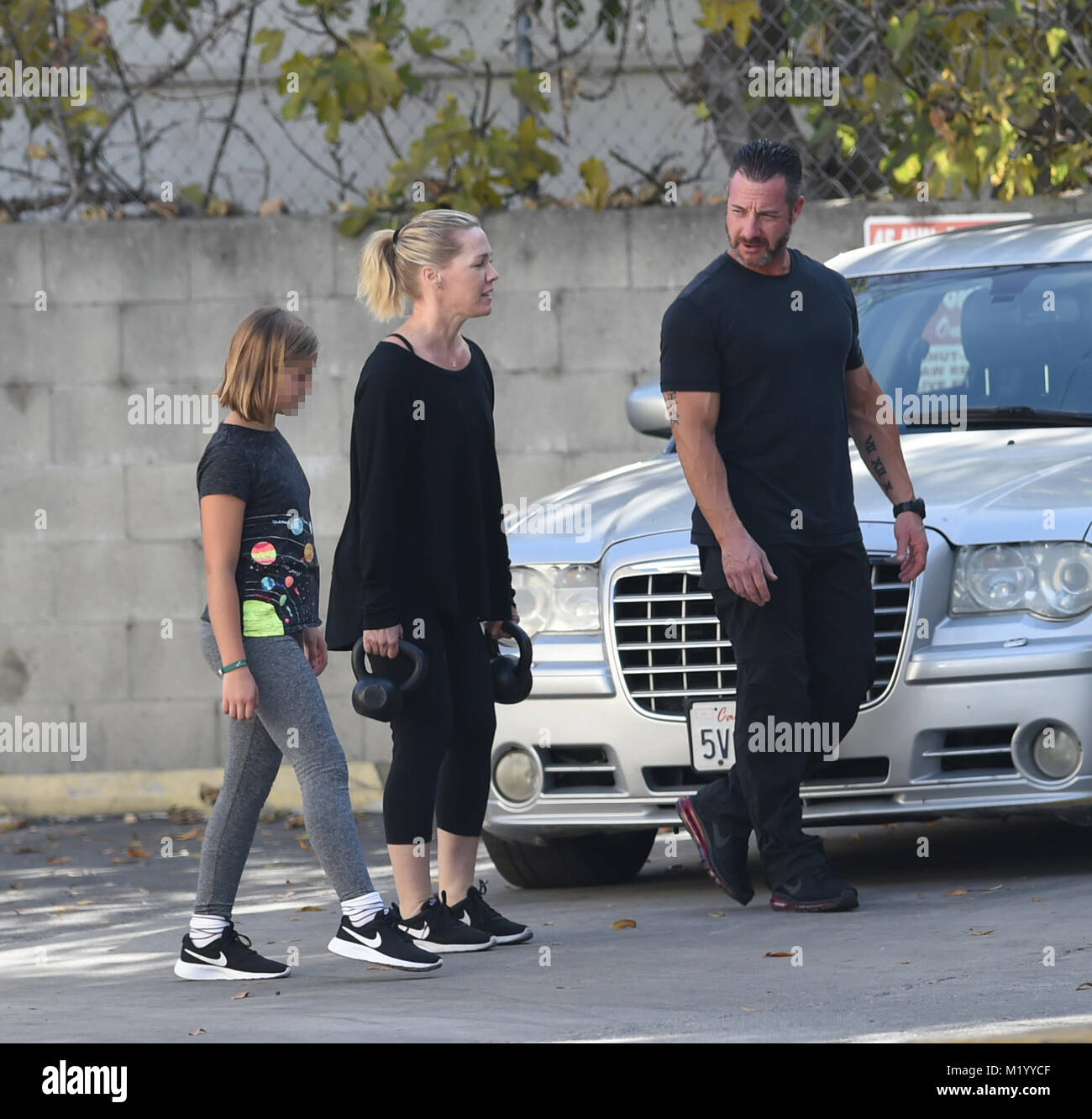 Jennie Garth does lunges with kettle bells with encouragement from her ...