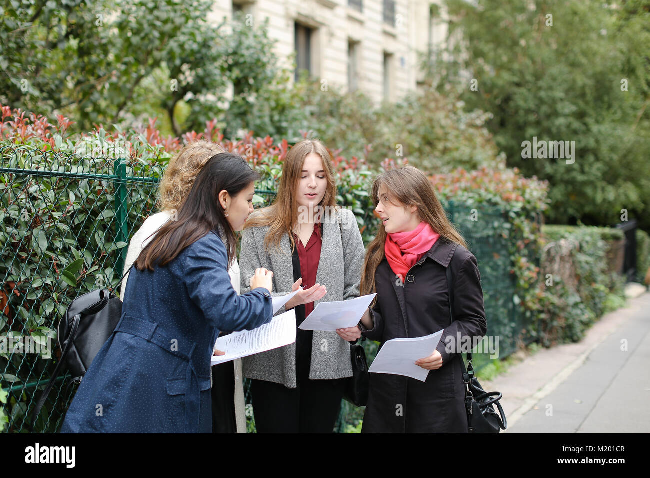 Foreign students learning English with papers near university bu Stock ...