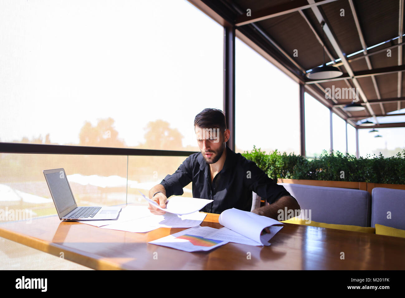 Office worker sorting papers on table near laptop Stock Photo - Alamy