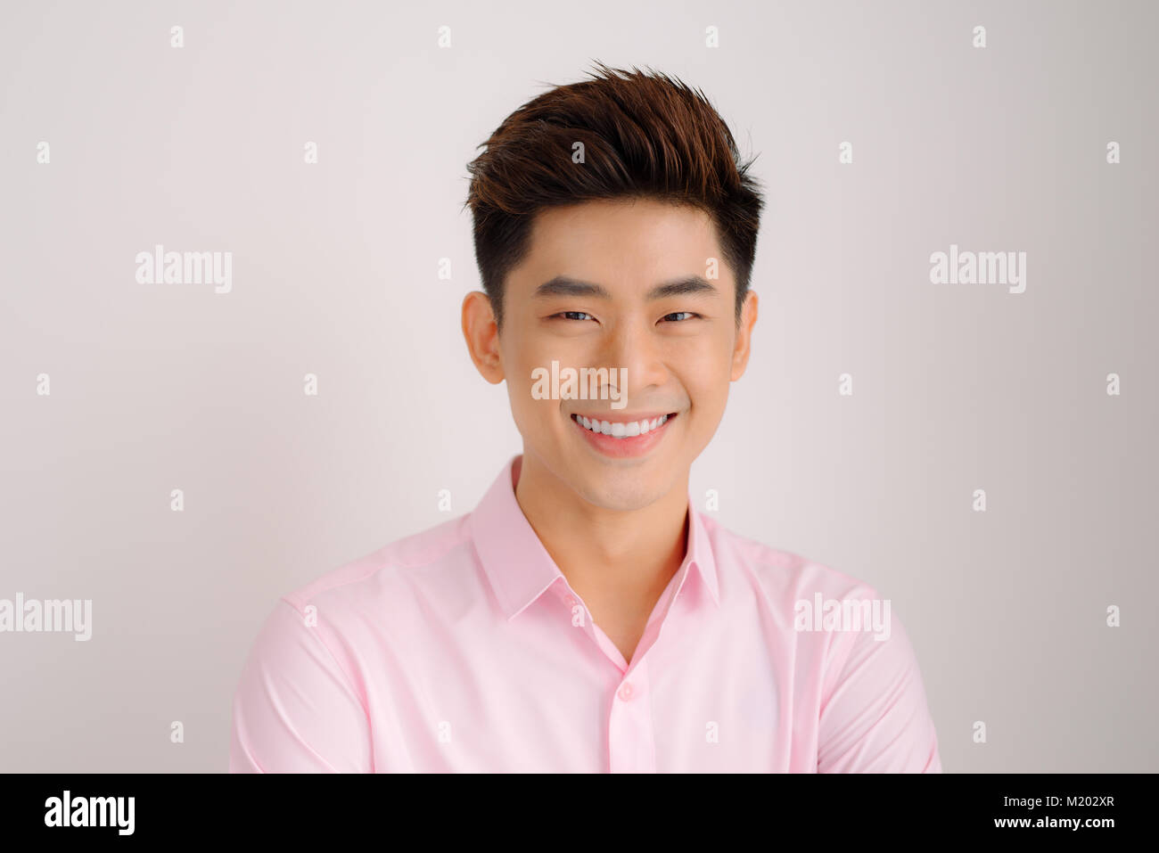 Handsome asian man stand and smile posing on gray background Stock ...