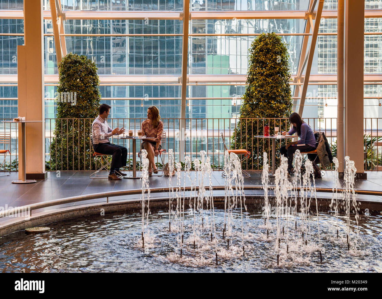 People at tables near fountain at Devonian Gardens, indoor park at Core Shopping Centre in ...