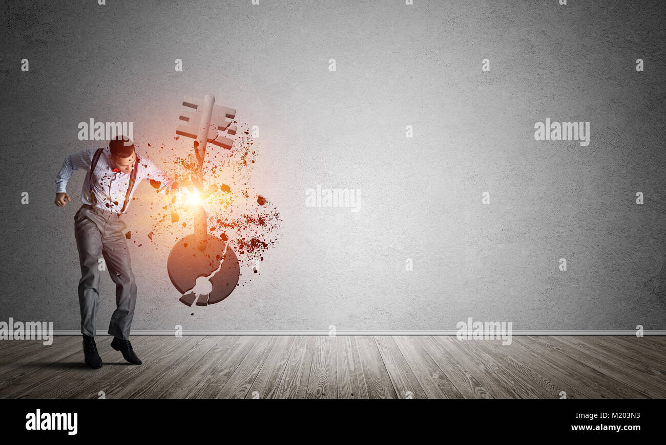 Breaking through access concept with man in room crashing concrete key ...