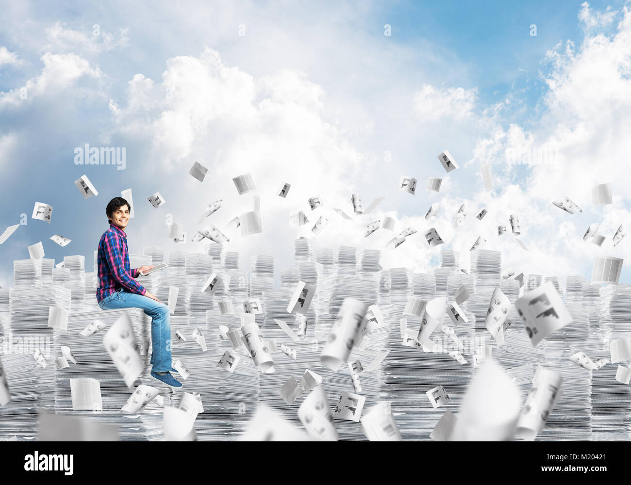 Attractive man sitting on pile of paper documents Stock Photo - Alamy