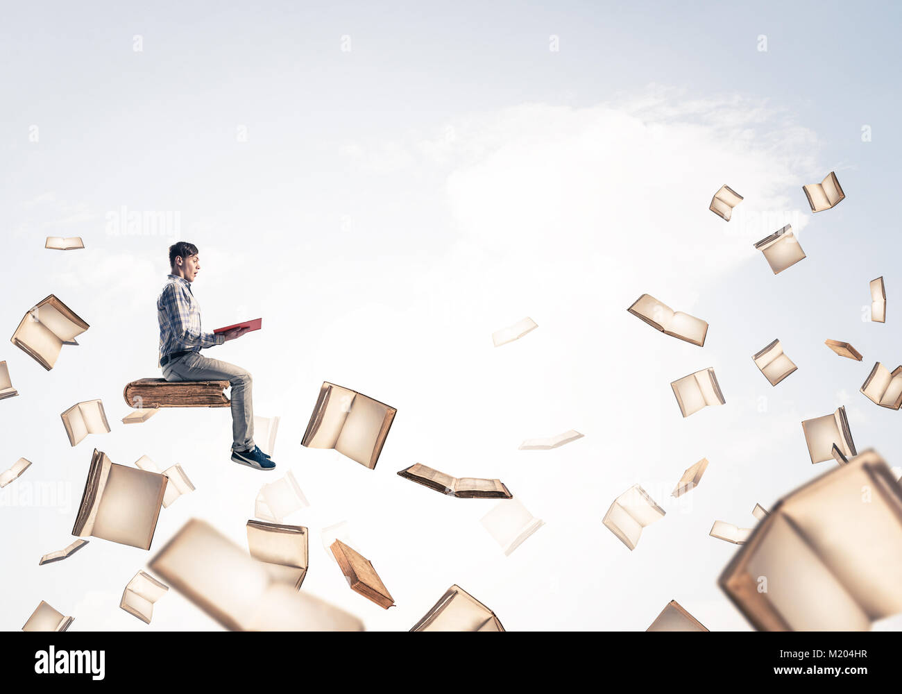 Man reading book and many of them flying in air Stock Photo - Alamy