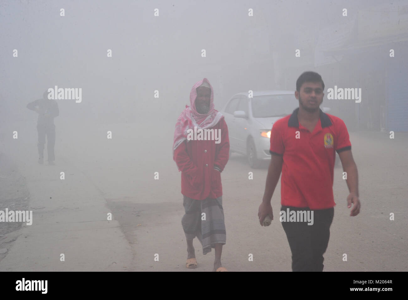 Bangladeshi peoples walks on the street on a cold and foggy winter ...