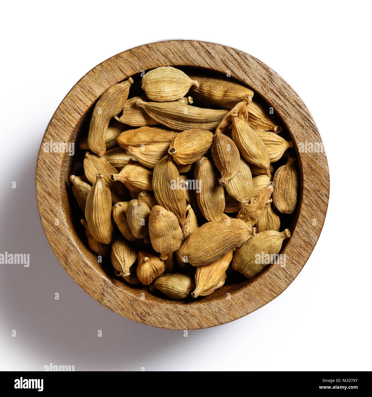 Dry cardamom pods in dark wood bowl isolated on white from above Stock ...