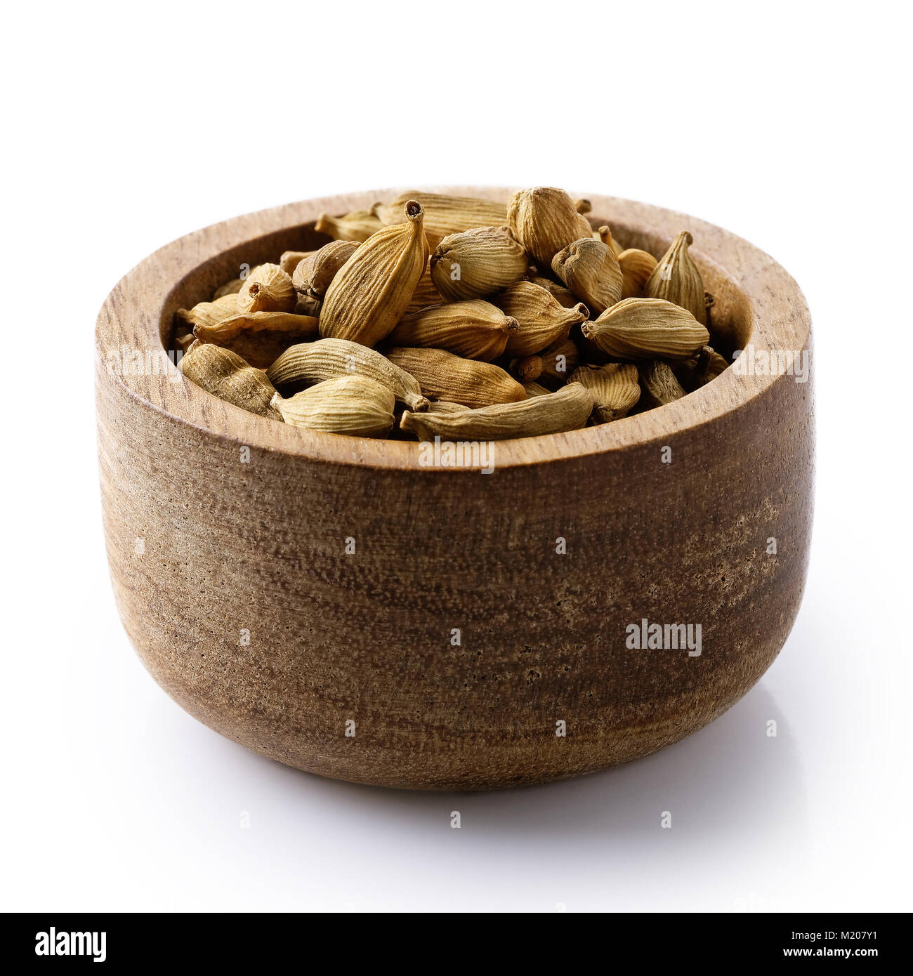 Dry cardamom pods in dark wood bowl isolated on white Stock Photo - Alamy
