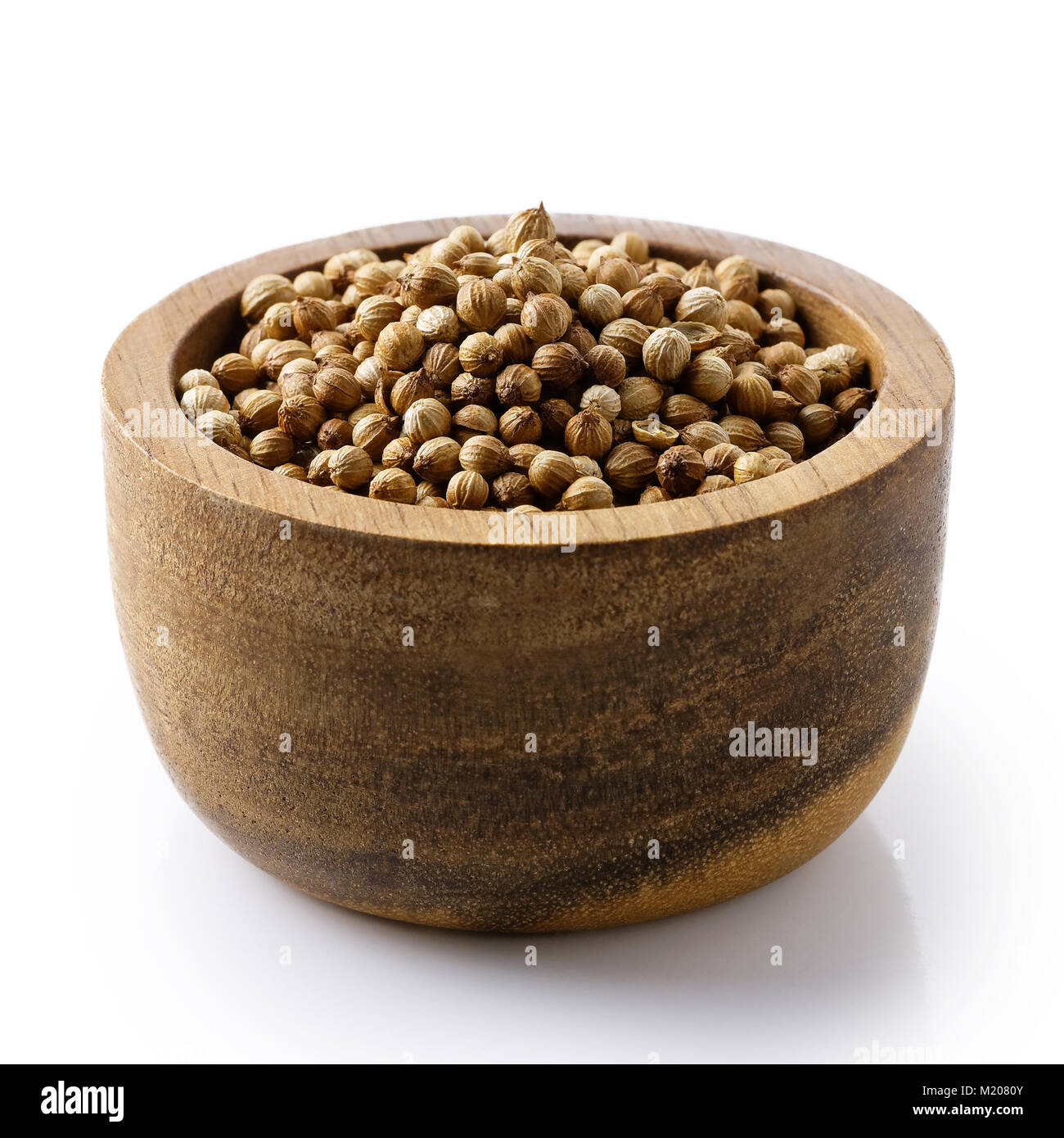 Whole dried coriander seeds in dark wood bowl isolated on white Stock Photo - Alamy