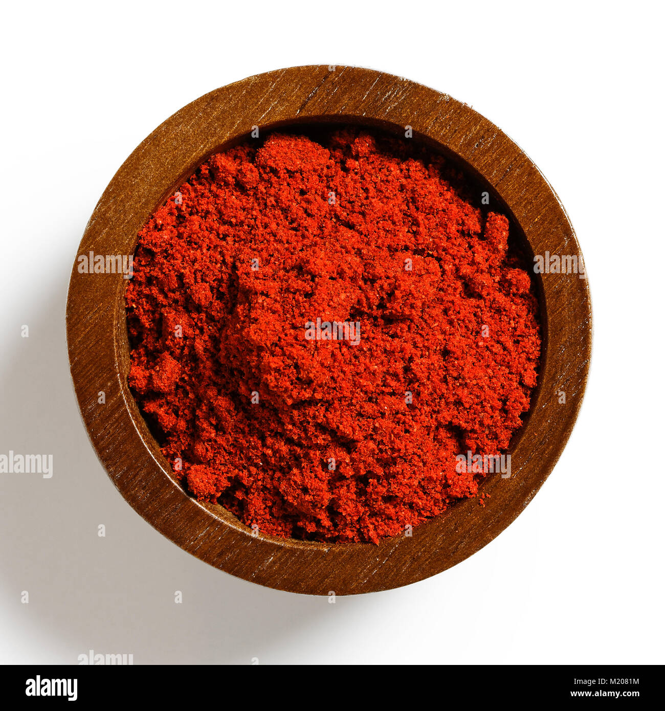 Paprika in dark wood bowl isolated on white from above Stock Photo - Alamy