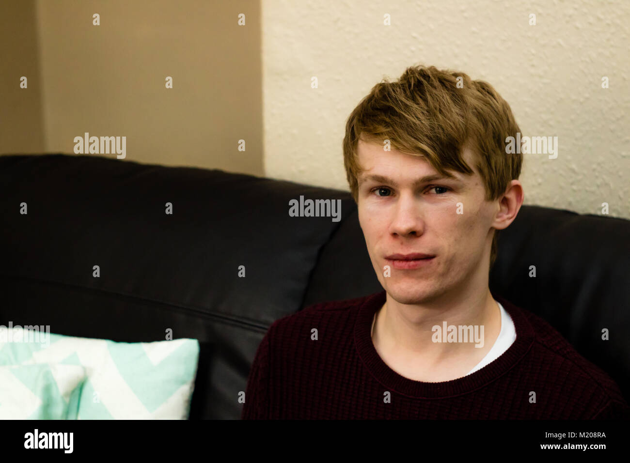 A young blonde man looking at the camera with a faint smile Stock Photo ...